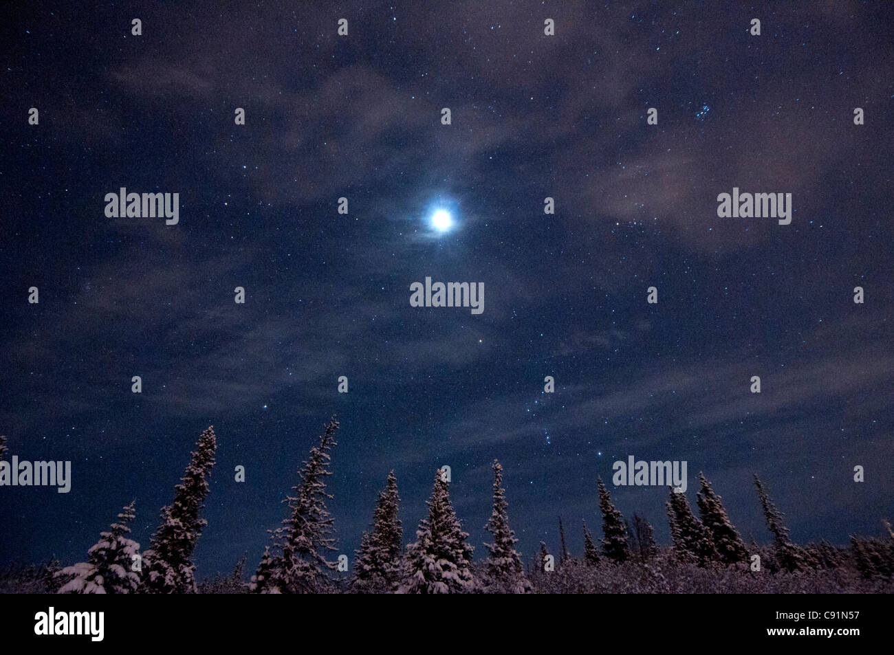 Full moon and a starry winter night over the hillside area above ...