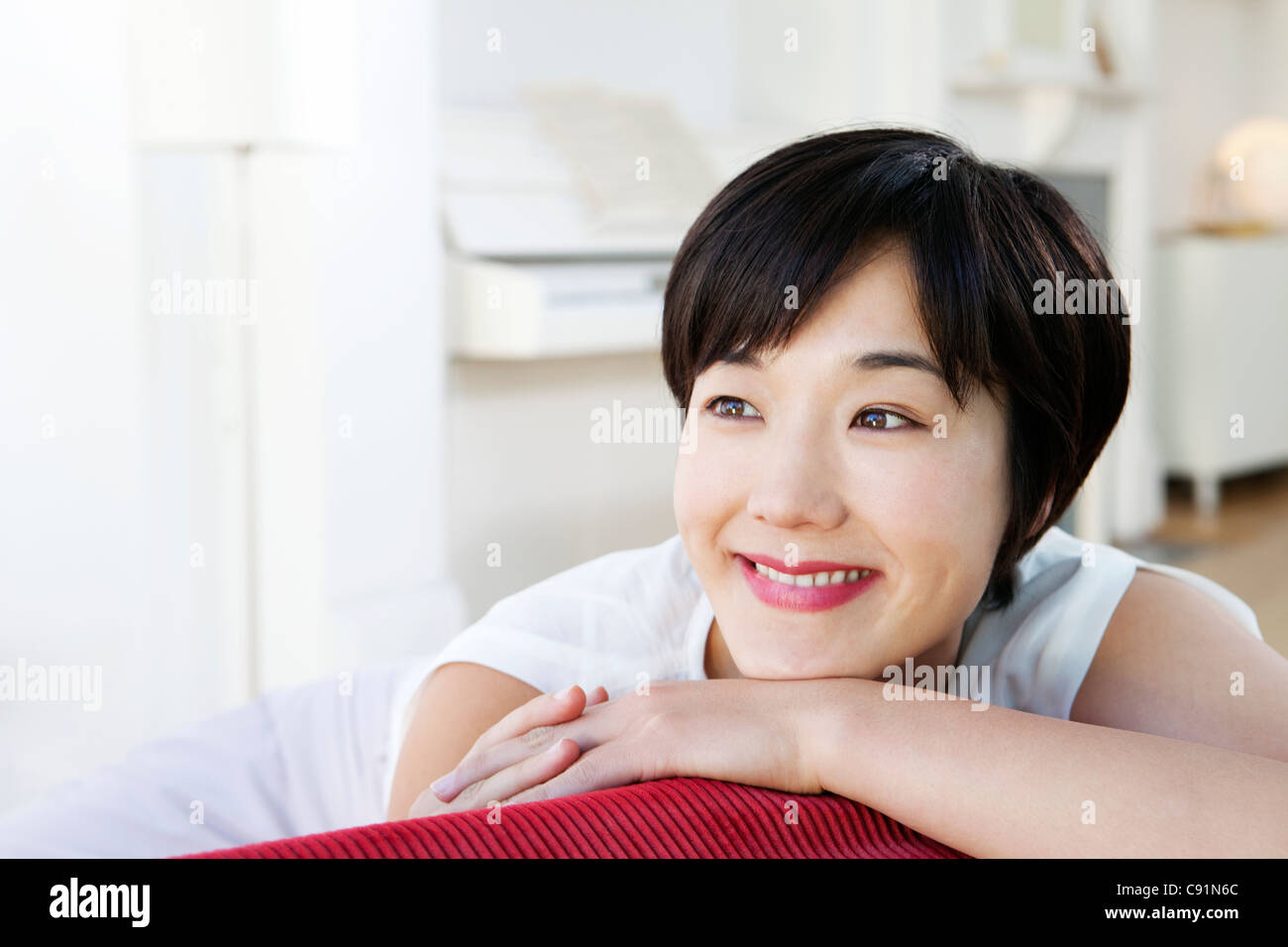 Smiling woman relaxing on sofa Stock Photo - Alamy