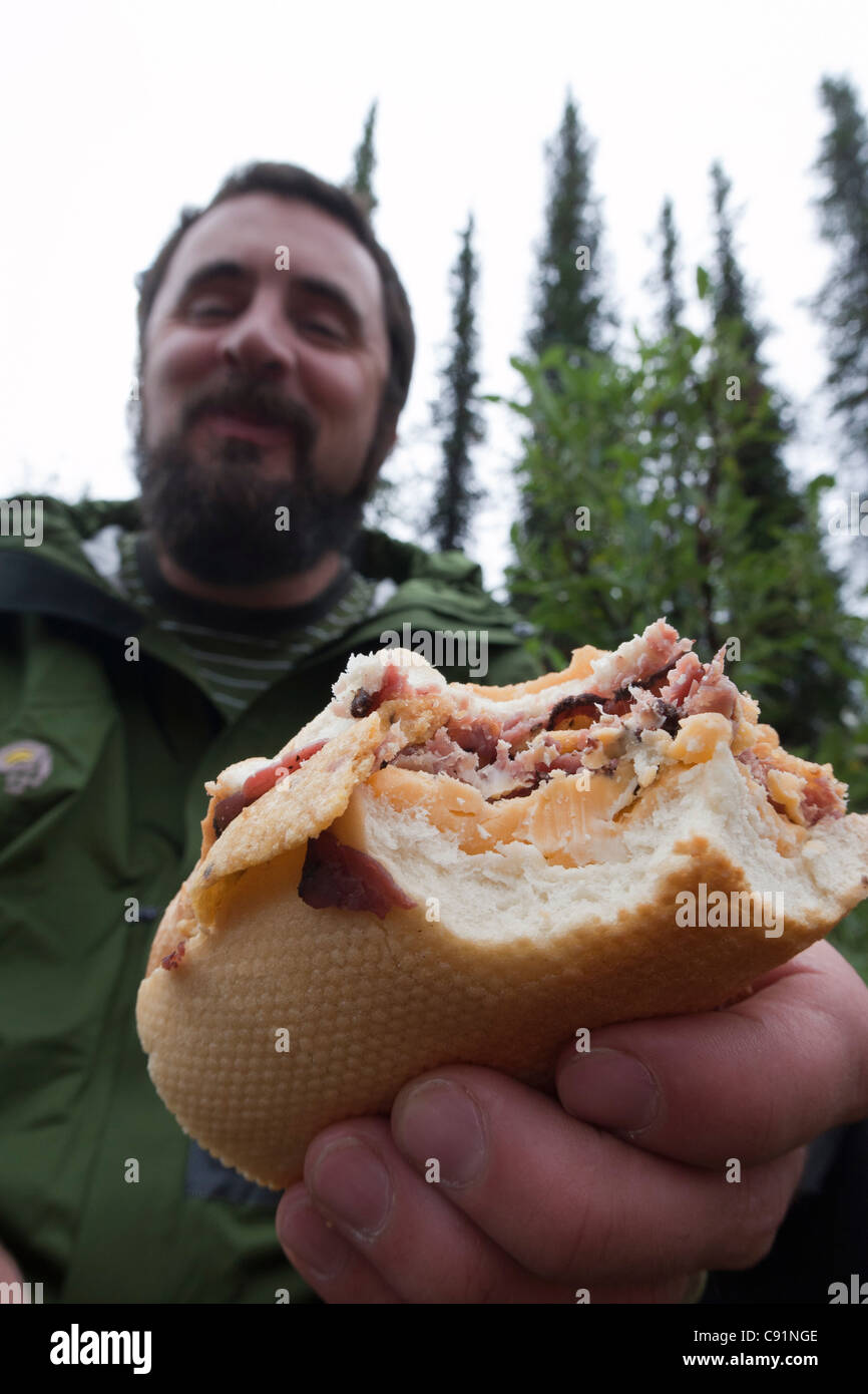 Man shows his half eaten sandwich during a lunch break enroute to ...