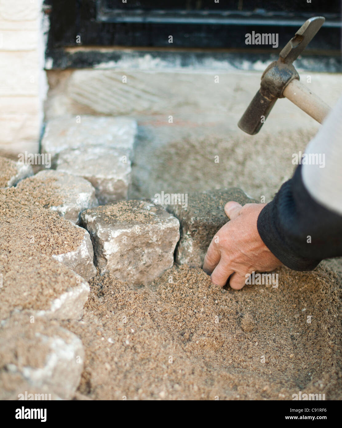 Paving with sand and hammer Stock Photo - Alamy