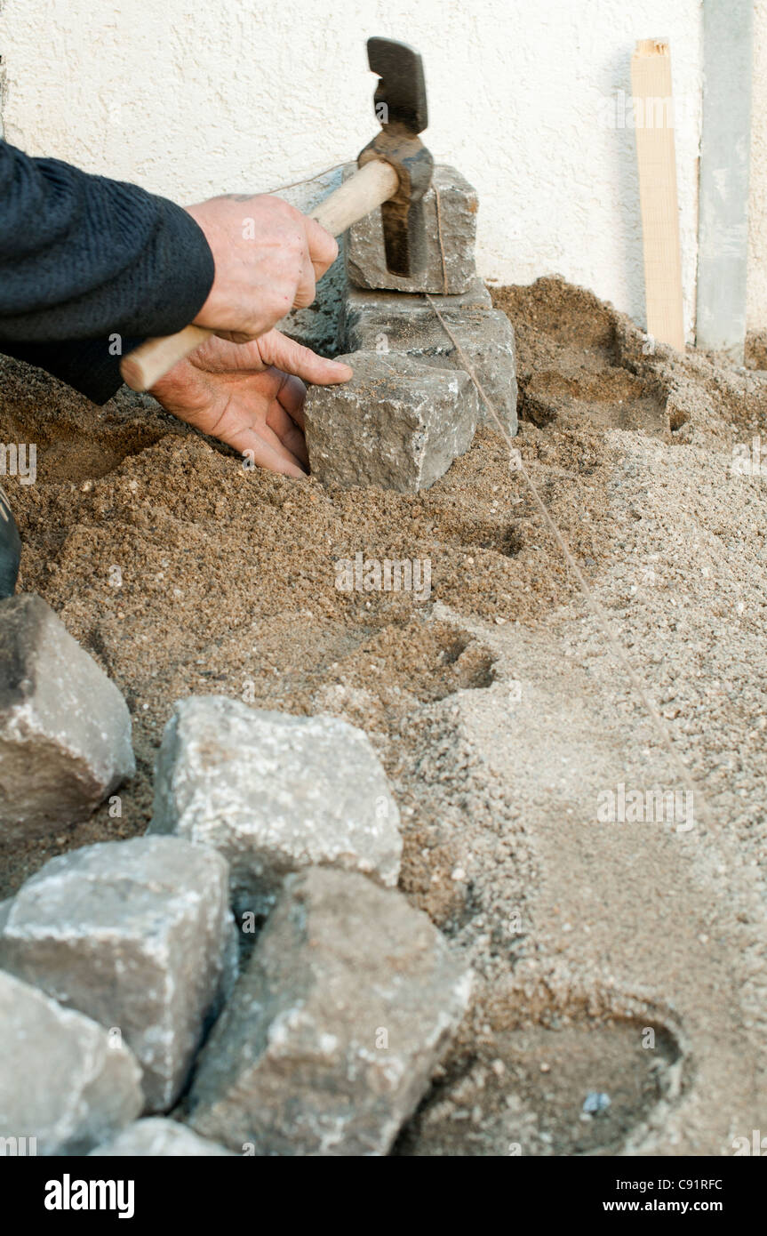 Paving with sand and hammer Stock Photo - Alamy