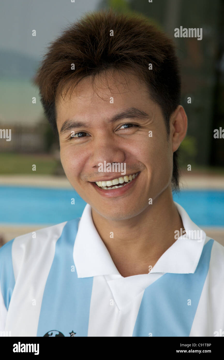 A young happy Thai man looking at camera Stock Photo - Alamy