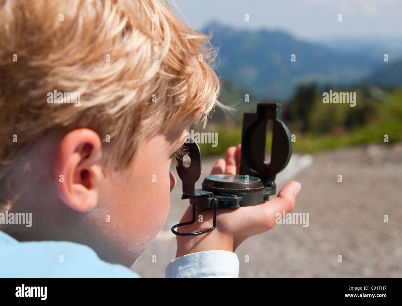 Boy using compass outdoors Stock Photo - Alamy