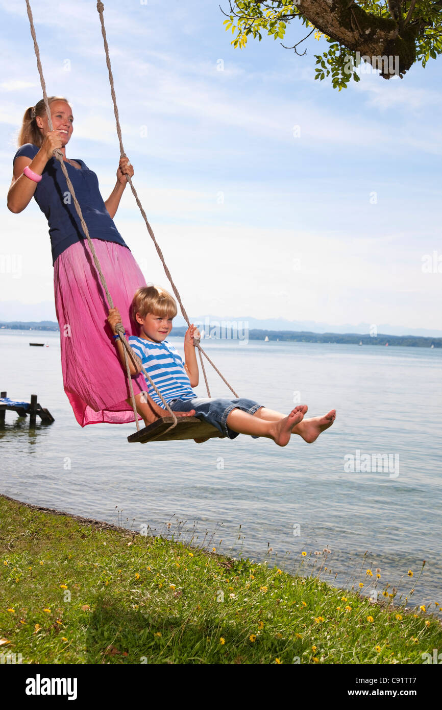 Mother and daughter swinging from tree Stock Photo - Alamy