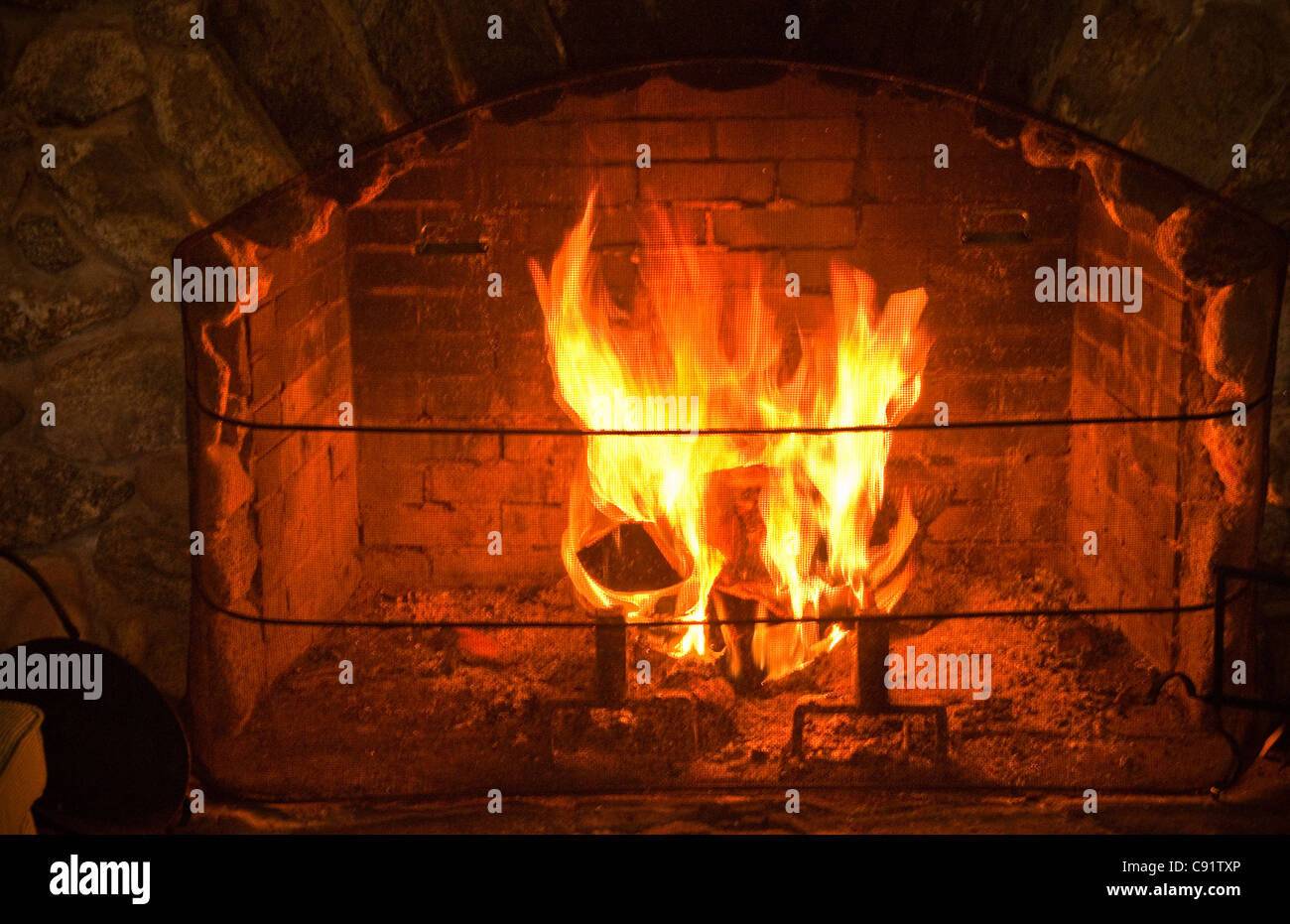 Warm fireplace flames provide cozy interior at summer vacation home ...