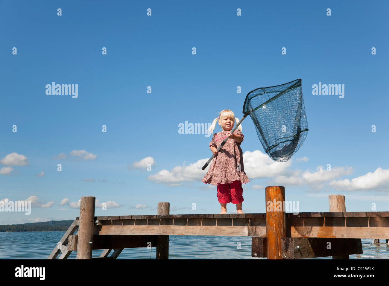 Girl fishing with net in lake Stock Photo - Alamy