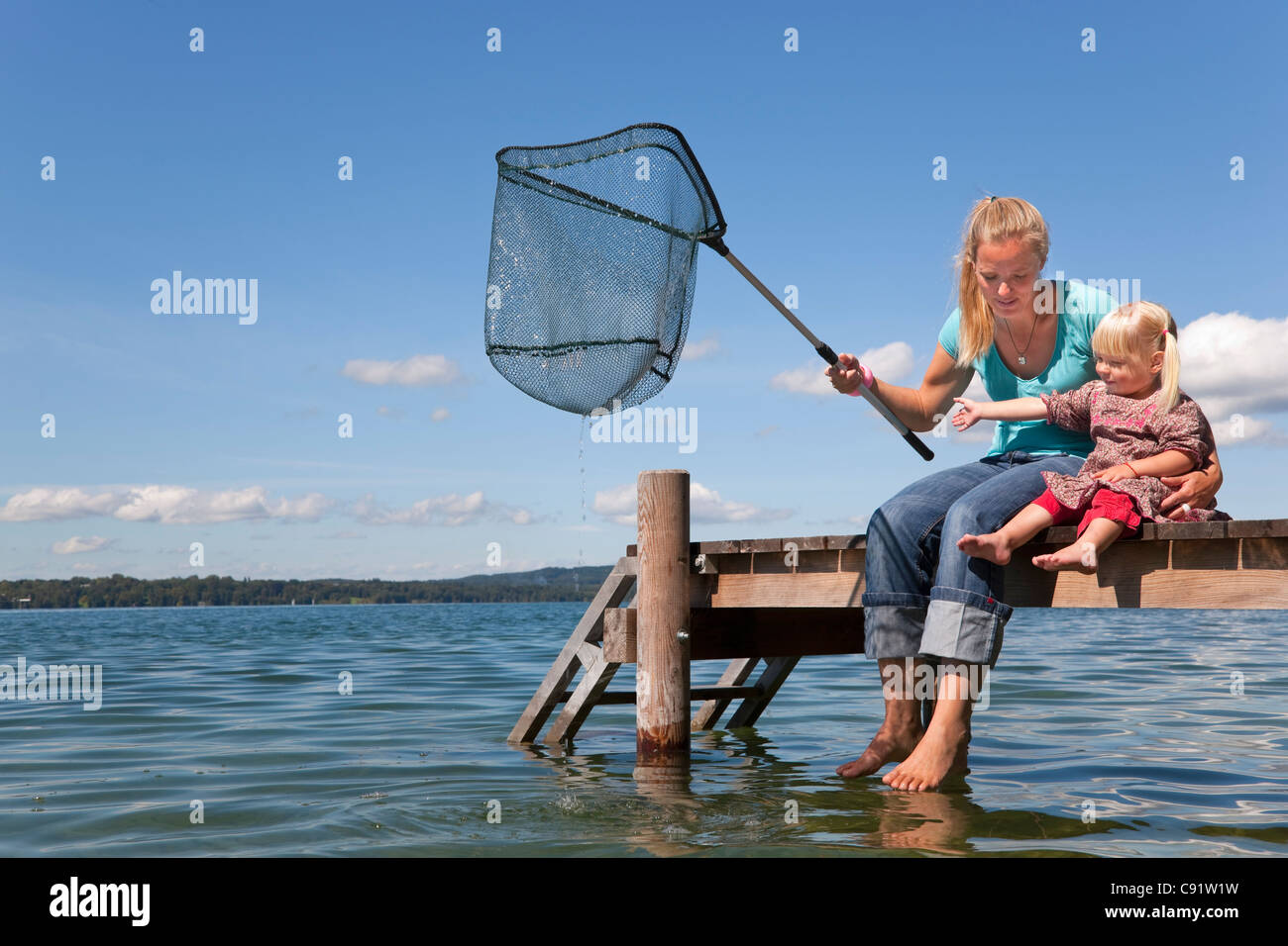 Mother and daughter fishing with net Stock Photo - Alamy