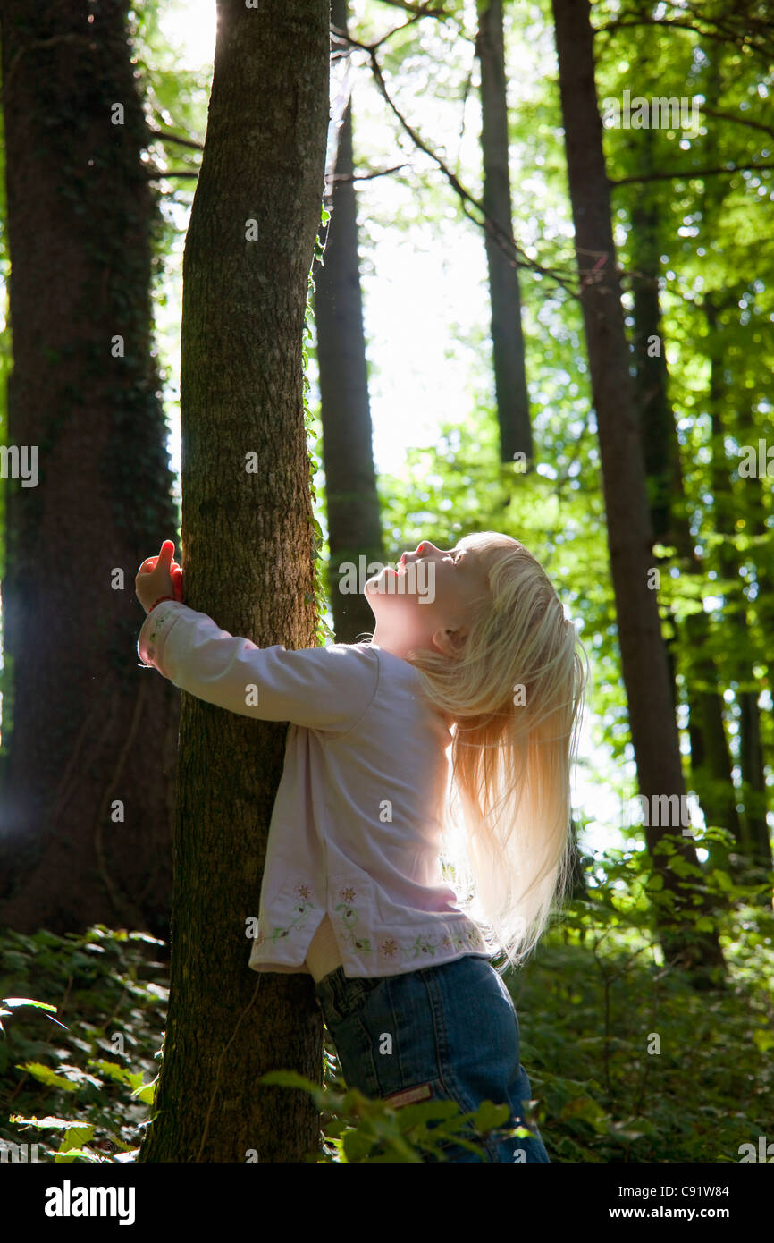 Girl hugging tree in forest Stock Photo - Alamy