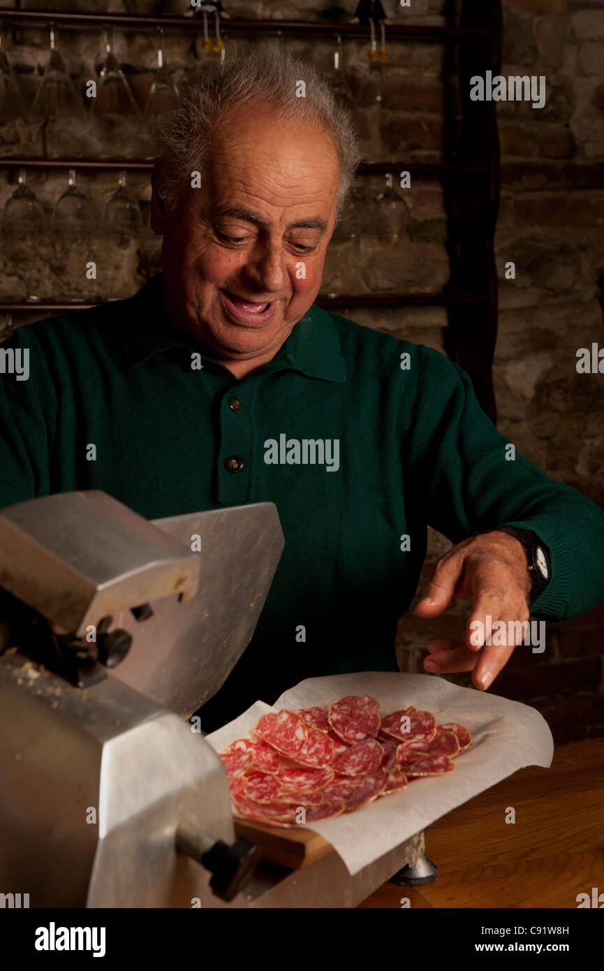 Italian man happily slicing salami Stock Photo - Alamy
