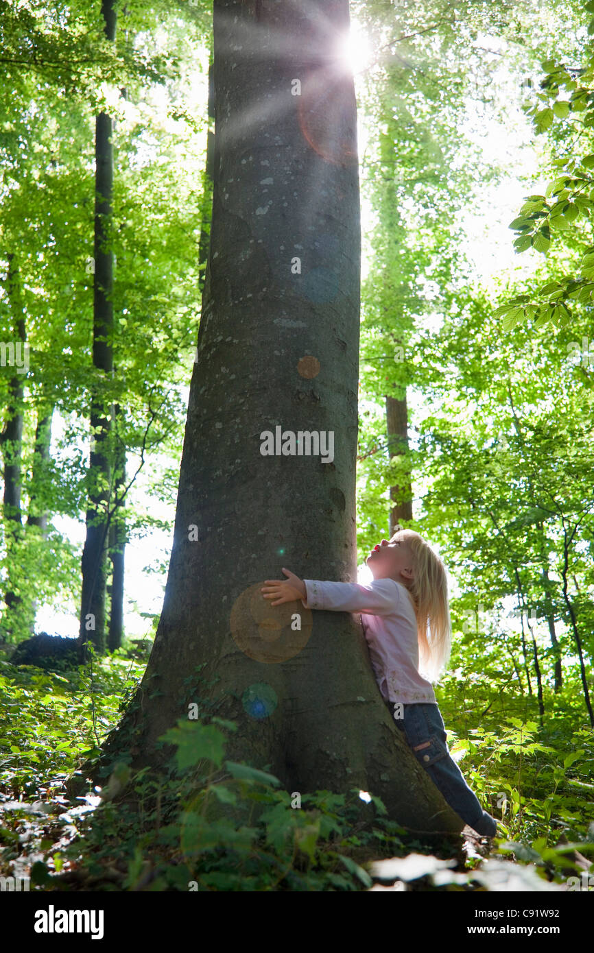 Girl hugging tree in forest Stock Photo - Alamy