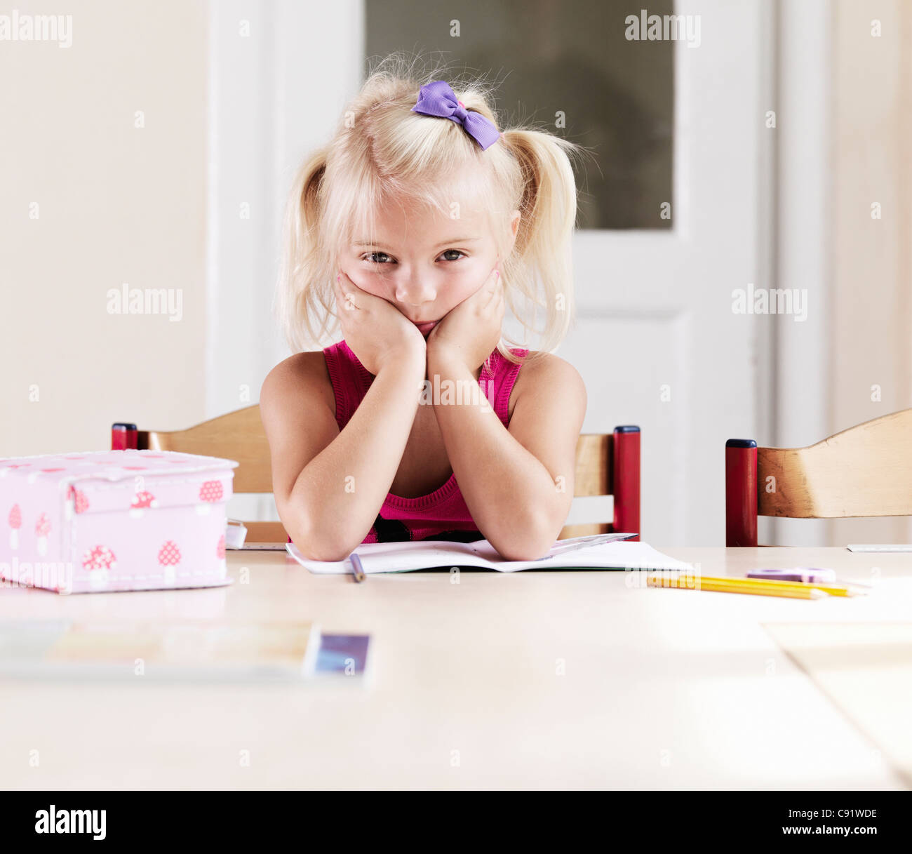 Bored girl doing homework at table Stock Photo - Alamy
