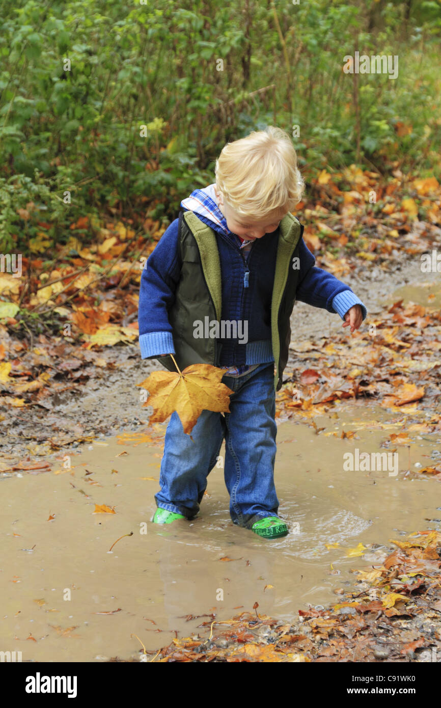 A toddler splashes in a muddy puddle Stock Photo - Alamy