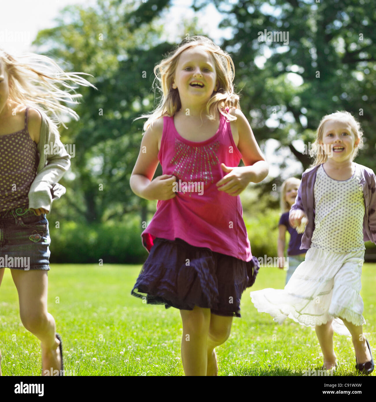 Smiling girls running in field Stock Photo - Alamy