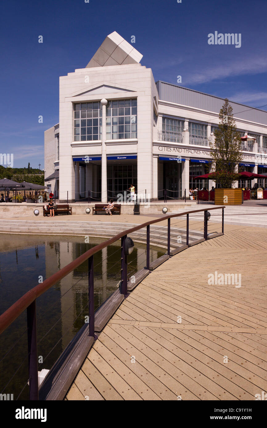 Wooden boardwalk decking with railing by lake and modern architecture ...
