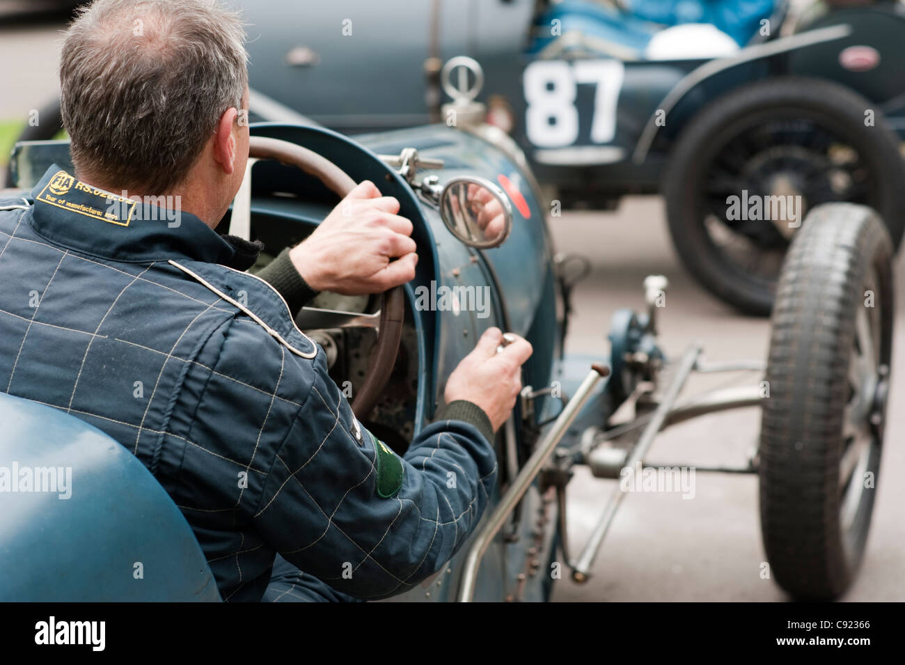 A Bugatti Type 35 and racing driver parked at a hill climb event. The ...