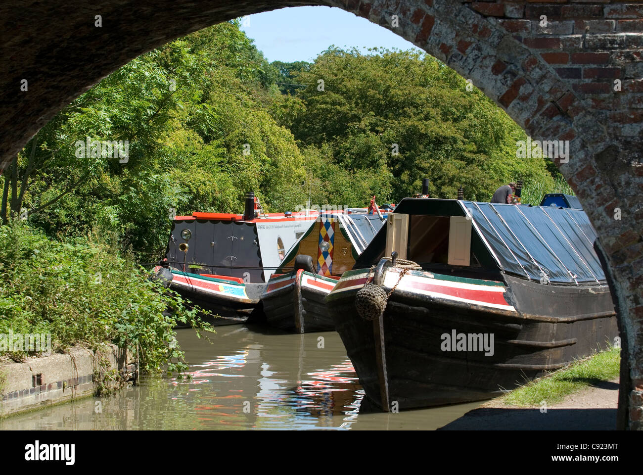 Grand Union Canal. A narrowboat passing under the bridge beside the ...