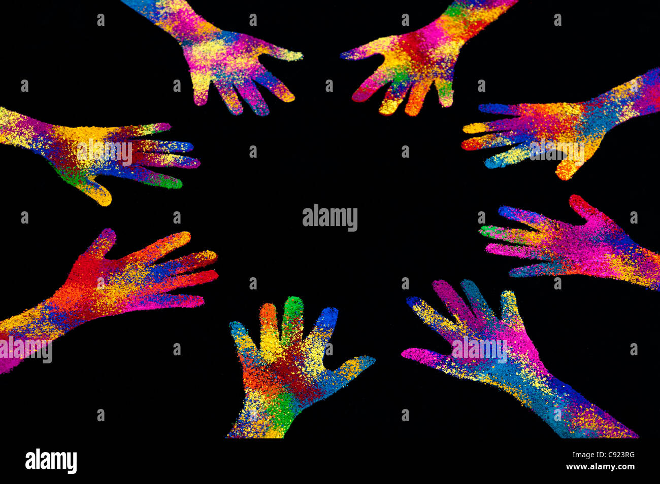 Coloured powder hand prints in a circular pattern on black Stock Photo ...