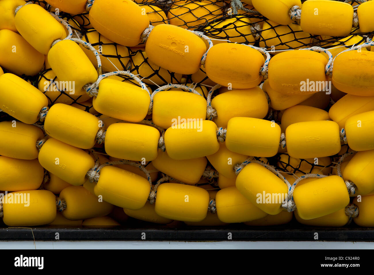 Bright yellow corks and commercial fishing seine net stacked on deck ...