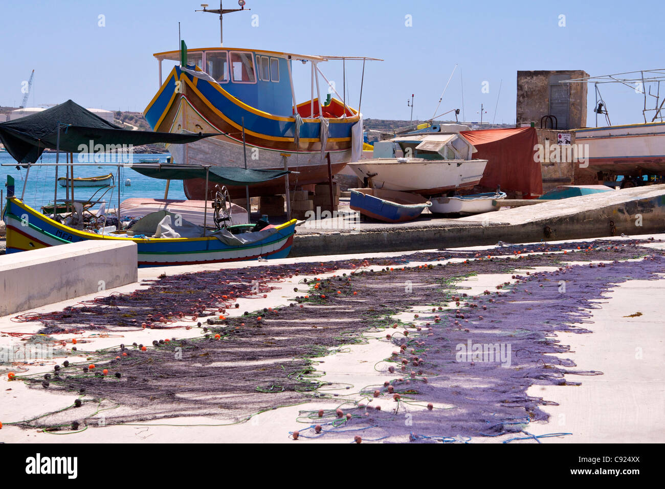 Lines of fishing nets laid out to dry on the harbour side in Marsaxlokk ...