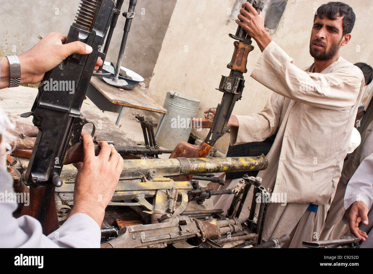 Former militia look at weapons at an army base, as part of a UN DDR ...