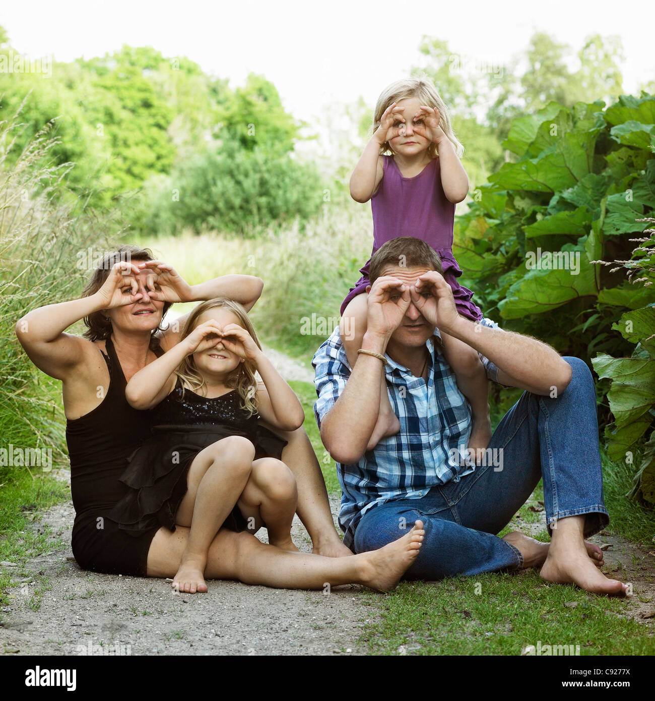 Family making faces on dirt path Stock Photo - Alamy