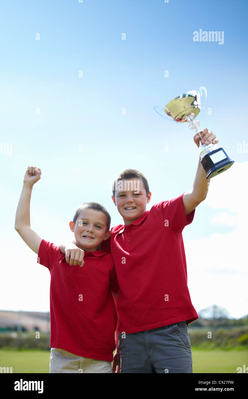 Boys cheering with trophy outdoors Stock Photo - Alamy