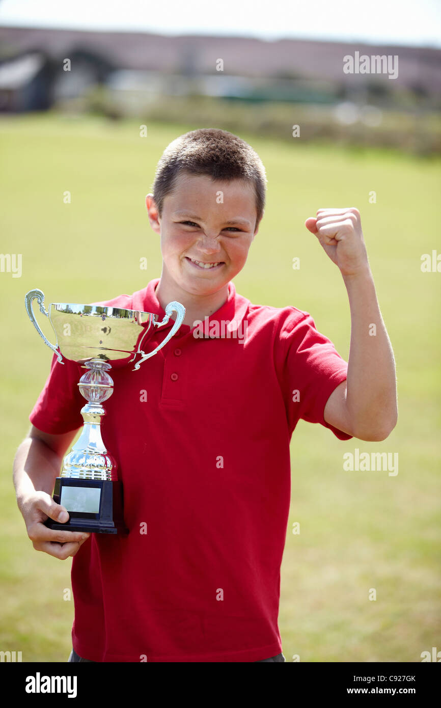 Boy cheering with trophy outdoors Stock Photo - Alamy