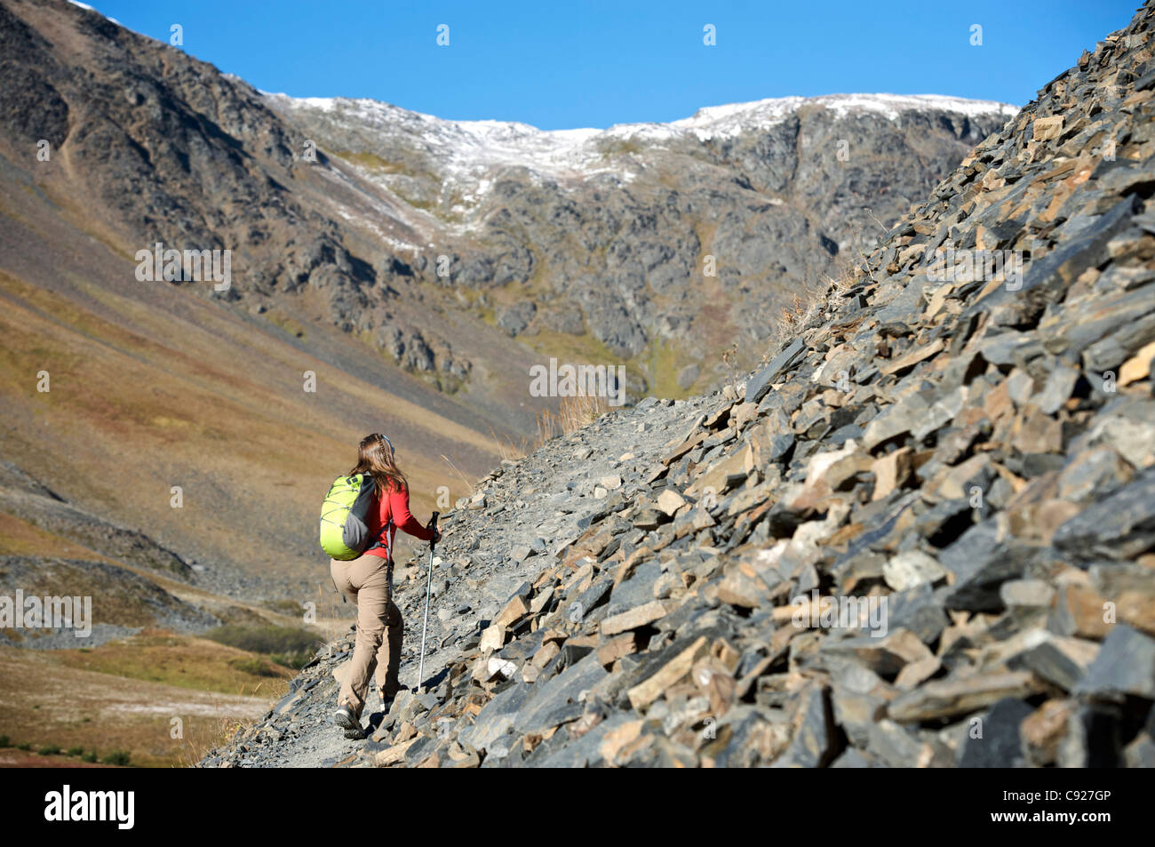 Woman hiking on the Crow Pass Trail along a steep rocky incline ...