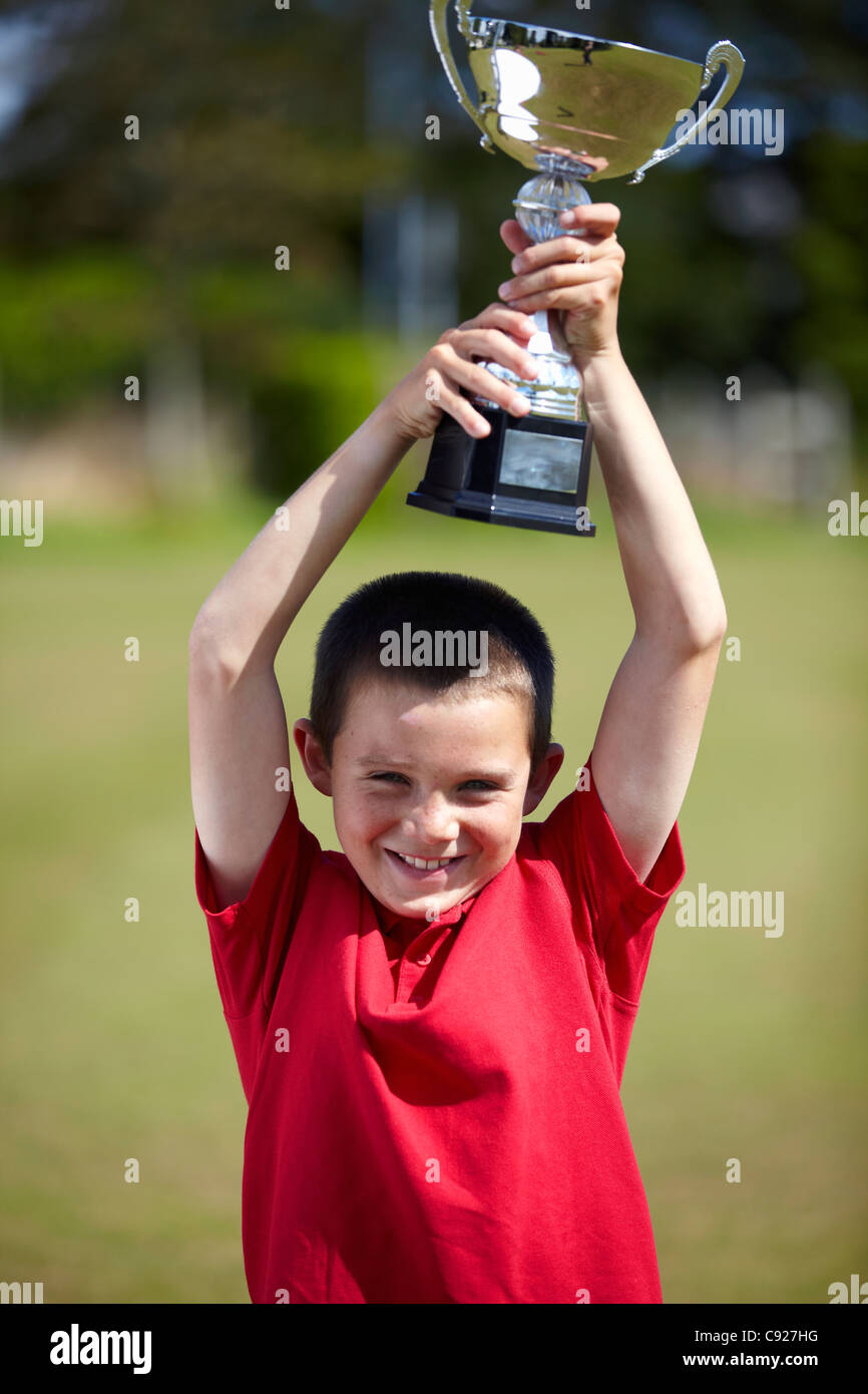 Boy cheering with trophy outdoors Stock Photo - Alamy