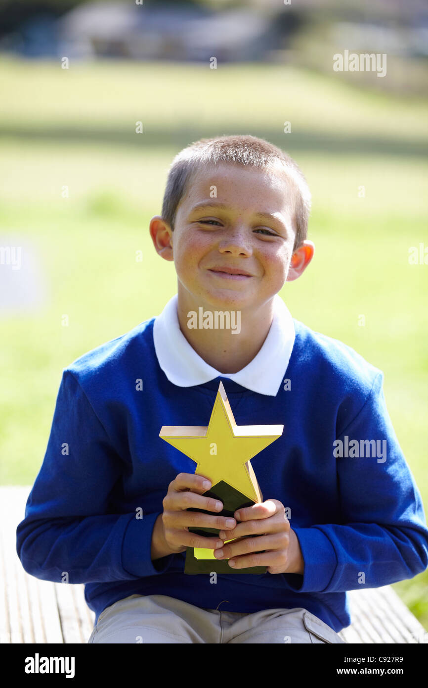Smiling boy holding trophy outdoors Stock Photo - Alamy