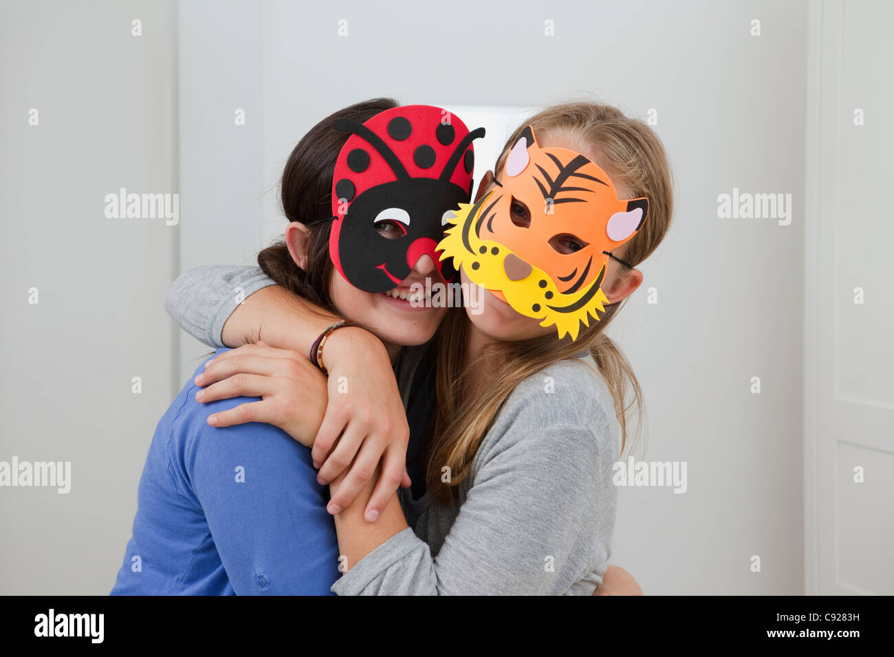 Smiling girls wearing colorful masks Stock Photo - Alamy