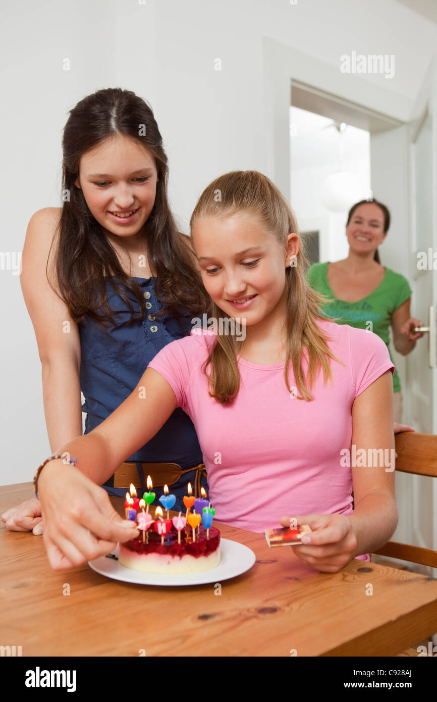 Girl lighting candles on birthday cake Stock Photo - Alamy