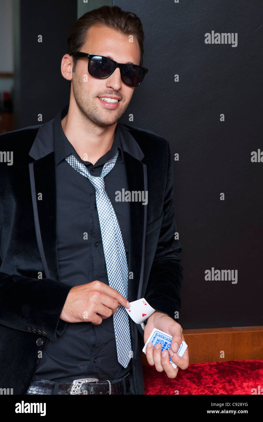 Man slipping cards up his sleeve Stock Photo - Alamy