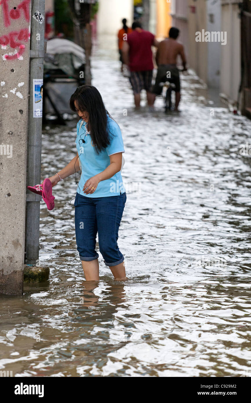 Woman wading through flood water in Bangkok city centre, Thailand Stock ...
