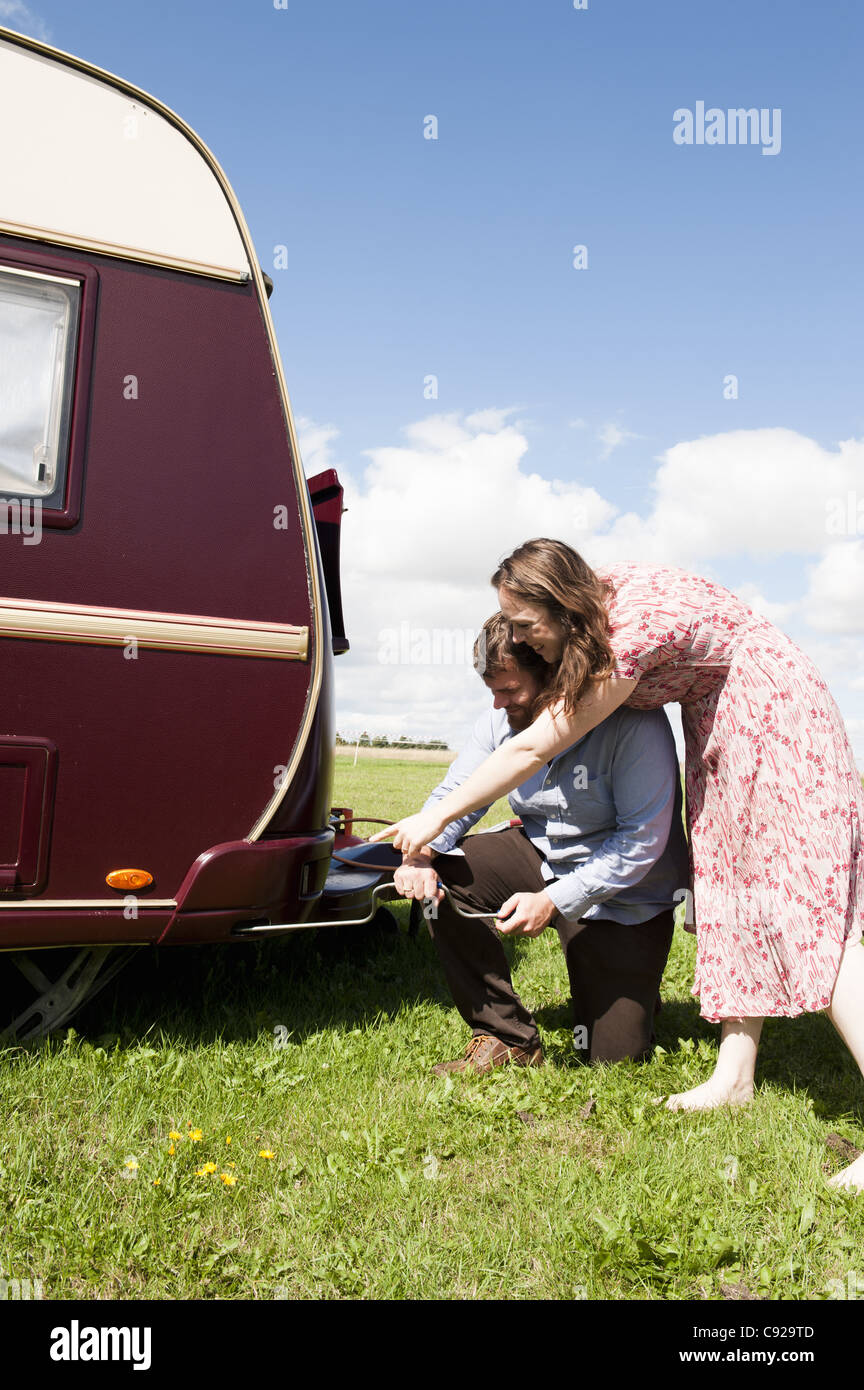 Couple working on trailer in field Stock Photo - Alamy