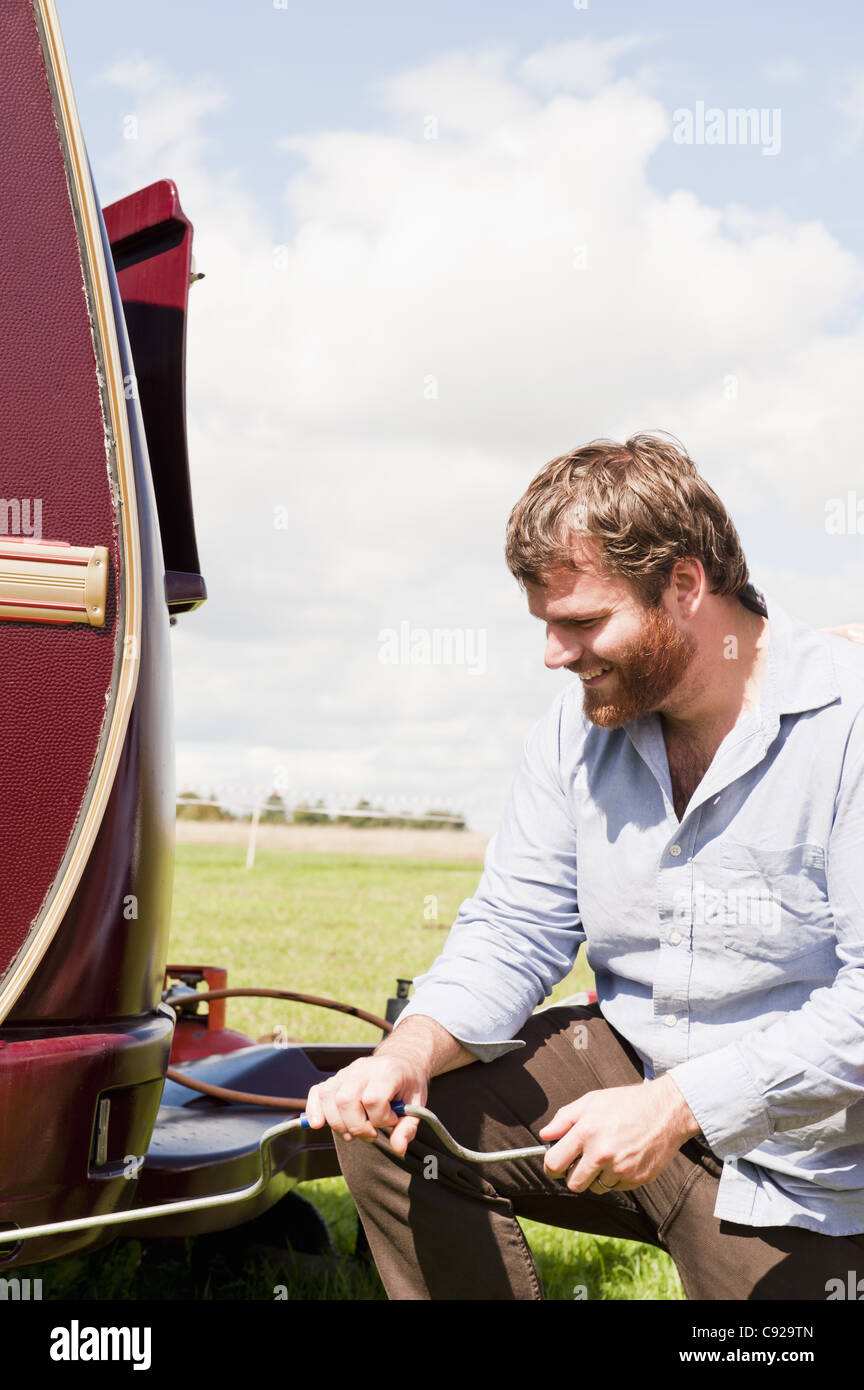 Man working on trailer in field Stock Photo - Alamy