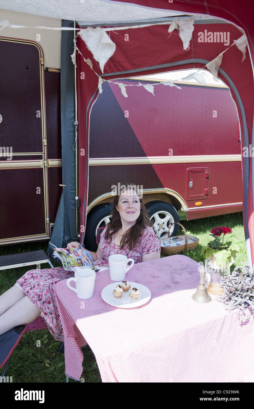 Woman reading magazine outside trailer Stock Photo - Alamy