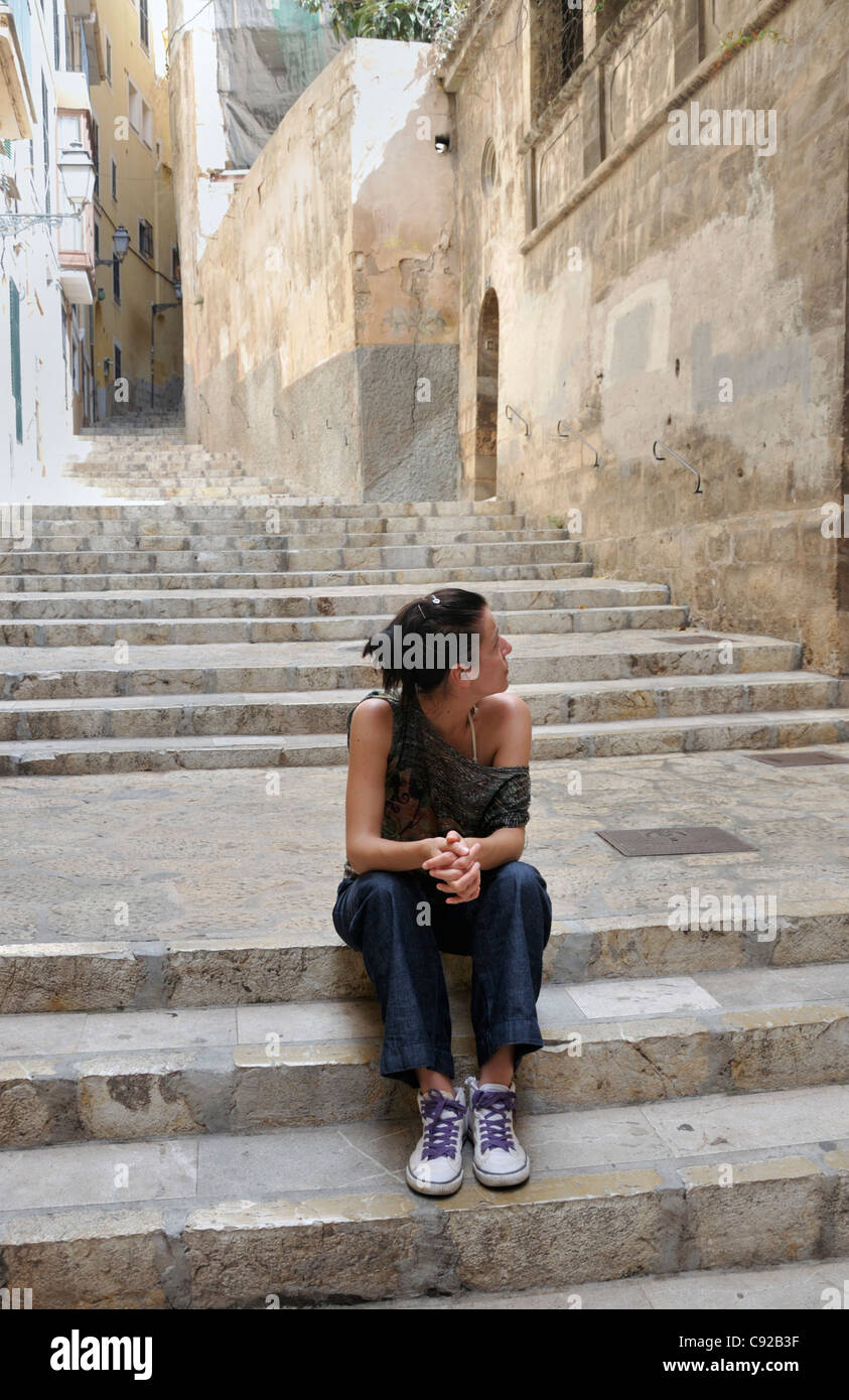 Young woman sitting on stairs Stock Photo - Alamy