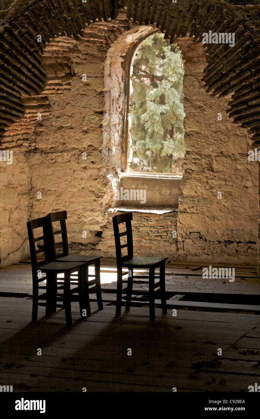 Ruins of an ancient Hamman Turkish Bath House with three wooden chairs ...