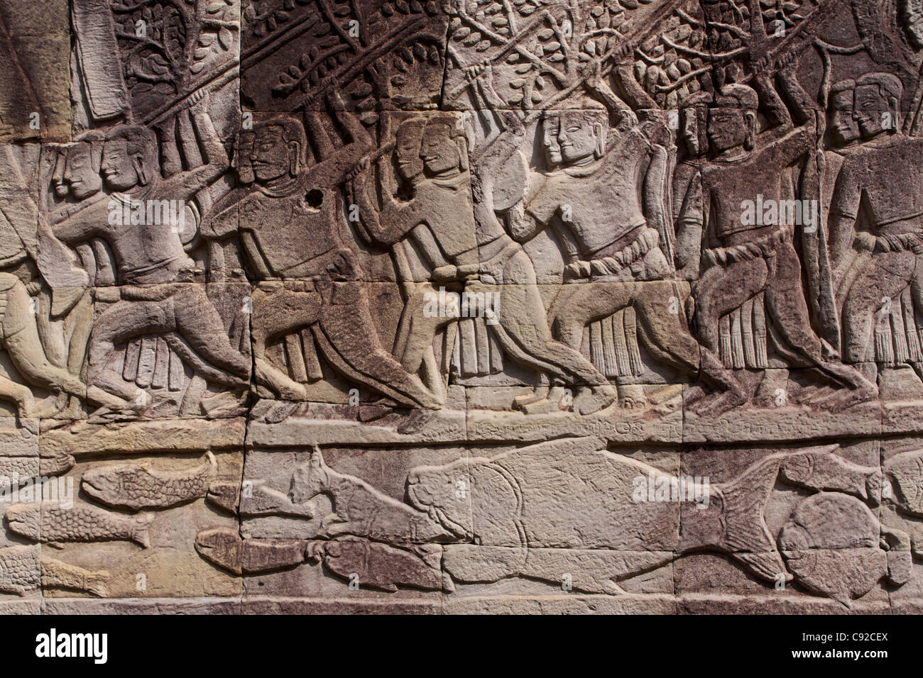 Carved stone bas-reliefs on the walls of the Bayon (the temple) within ...