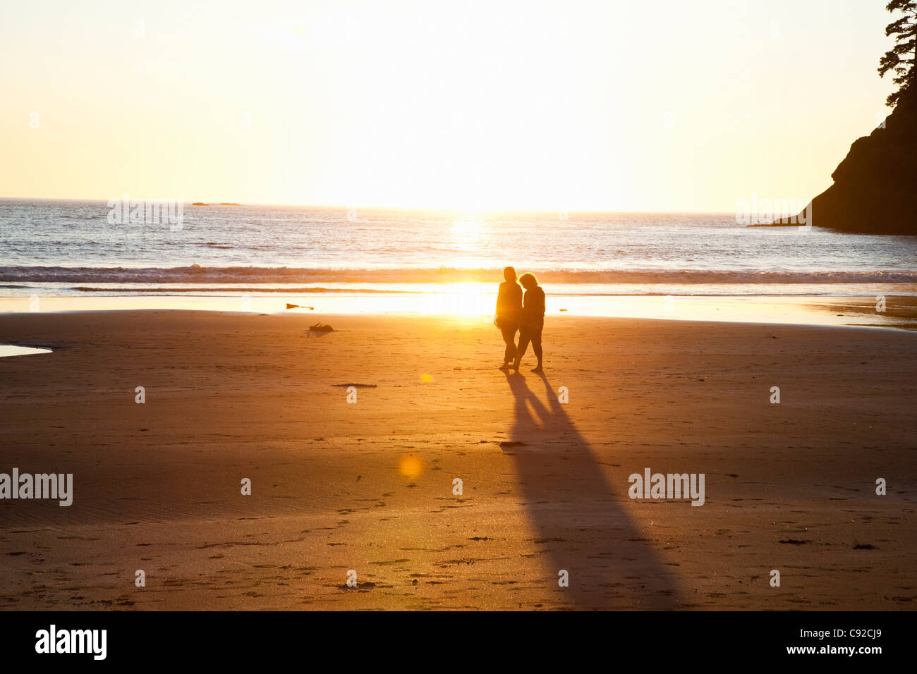 Couple walking on beach on sunset Stock Photo - Alamy