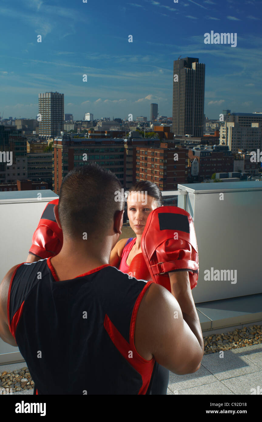 Woman boxing with coach on rooftop Stock Photo - Alamy