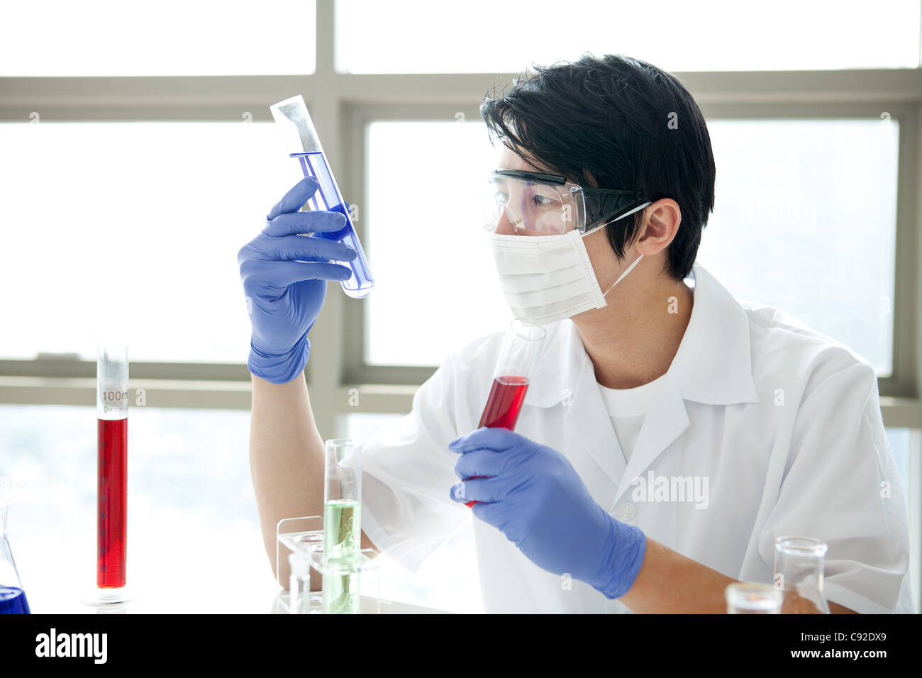 Scientist holding two liquid fill test tubes Stock Photo - Alamy