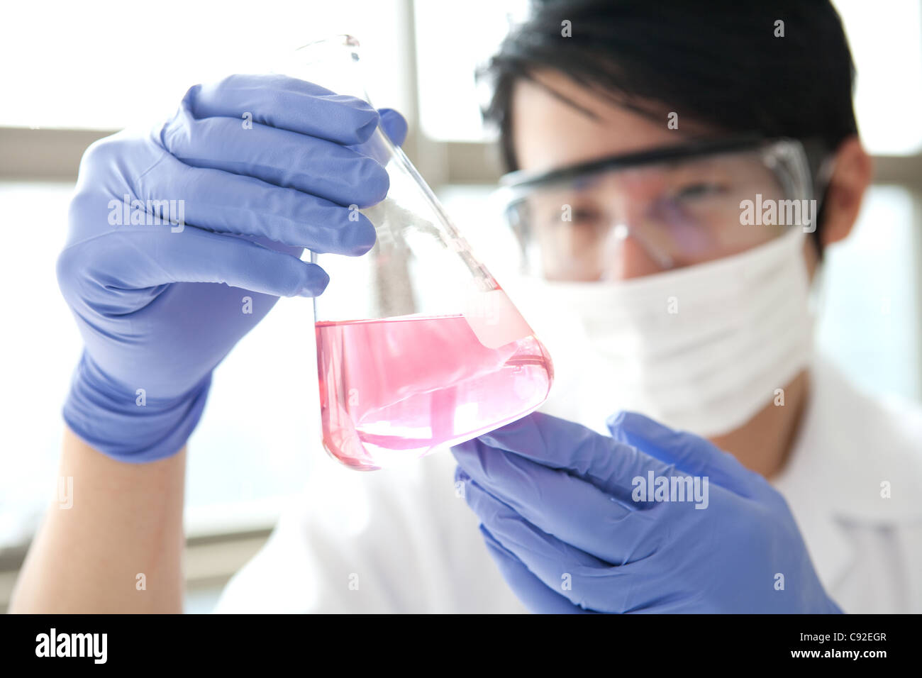 Scientist holding glass beaker Stock Photo - Alamy