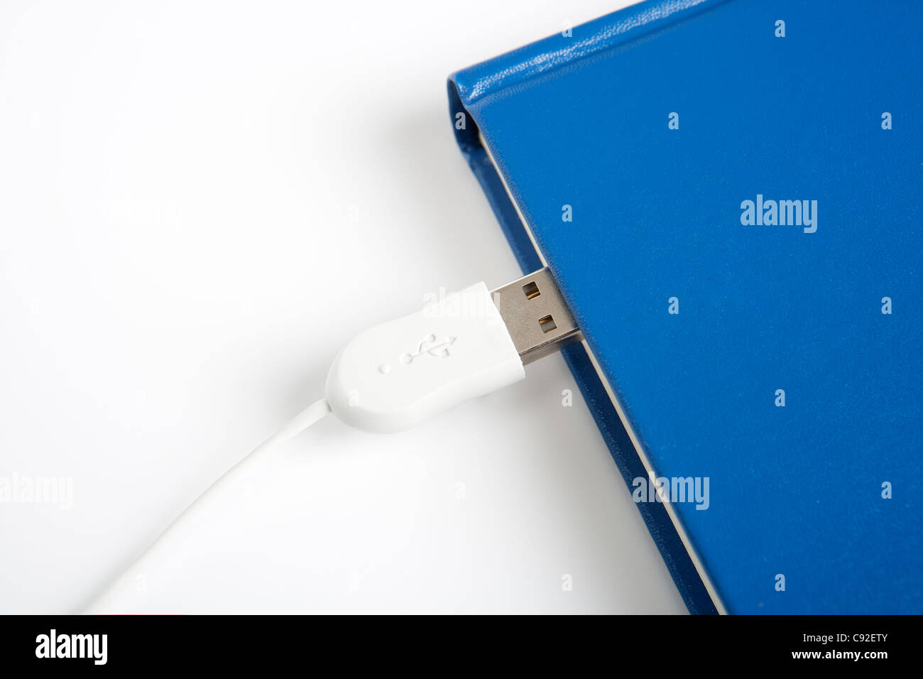 USB Cable connected to blue book, close-up Stock Photo - Alamy