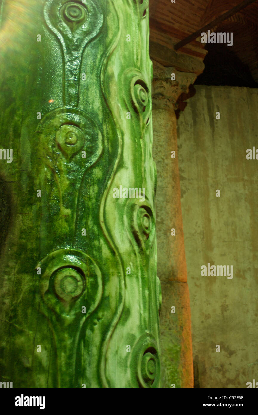 Carved column covered with green algae in the ancient underground ...