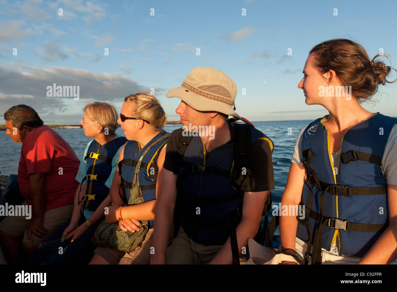 Tourists sitting on a boat, Punta Suarez, Espanola Island, Galapagos ...