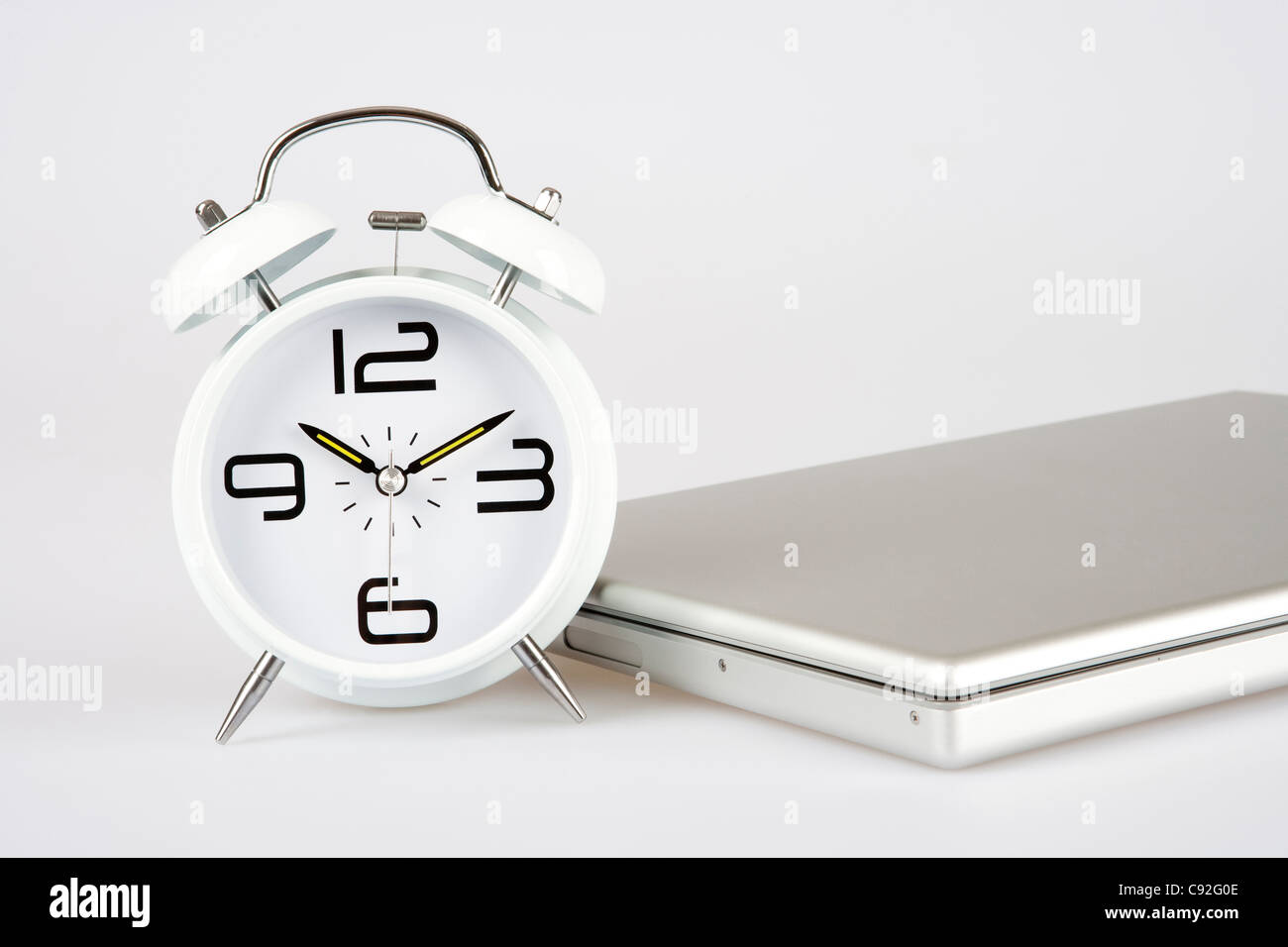 Alarm clock with laptop Stock Photo - Alamy