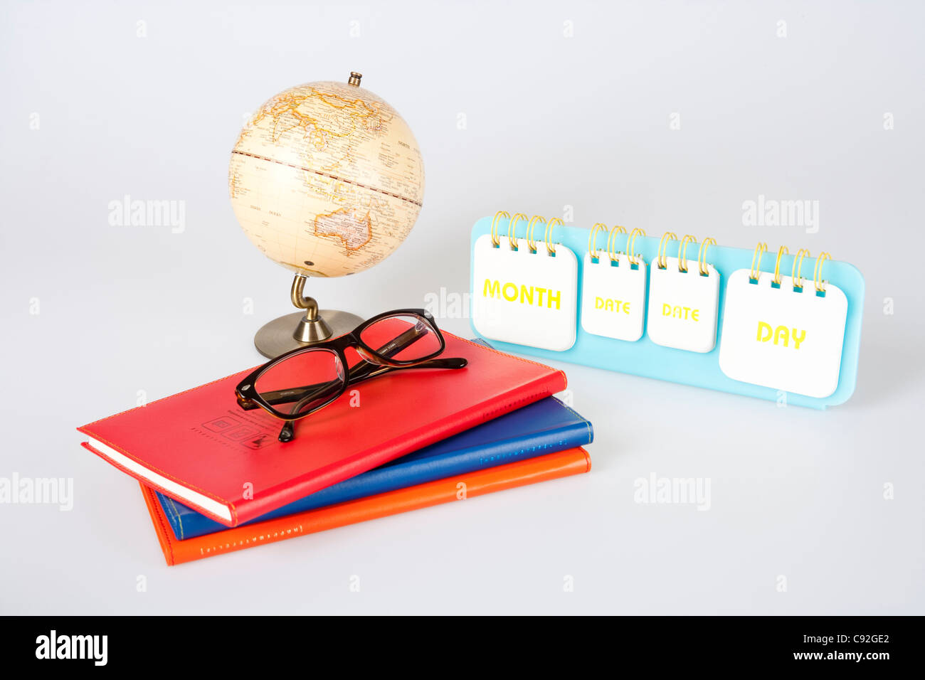 Calendar with globe and stack of books Stock Photo - Alamy