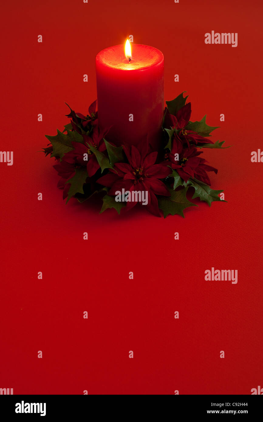 A red color candle between flowers Stock Photo - Alamy